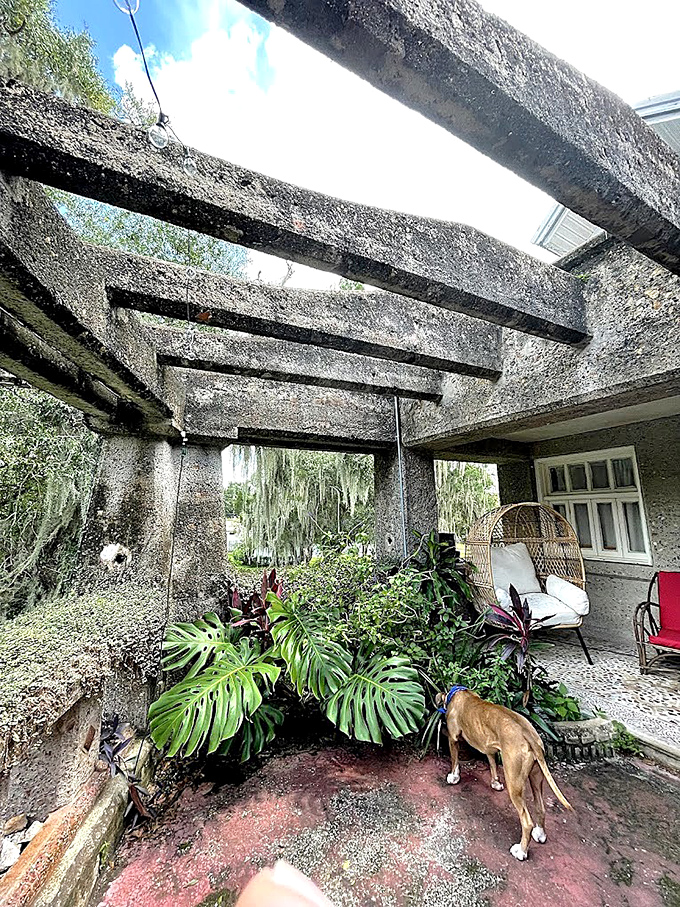 The exterior pergola creates a liminal space between indoors and out, where concrete beams frame views of the Florida sky.