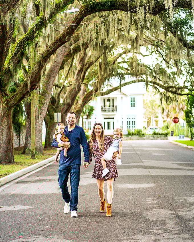 A family creates memories beneath centuries-old branches, walking where countless generations have strolled before them.