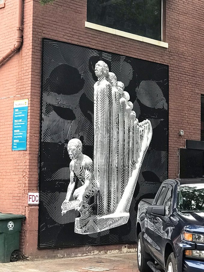 Street art adorns nearby buildings, extending the park's creative spirit beyond its boundaries with striking black and white optical illusions.