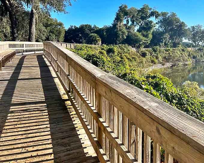 A wooden boardwalk leads to Moultrie Creek, offering peaceful moments of natural beauty just steps away from this architectural marvel.