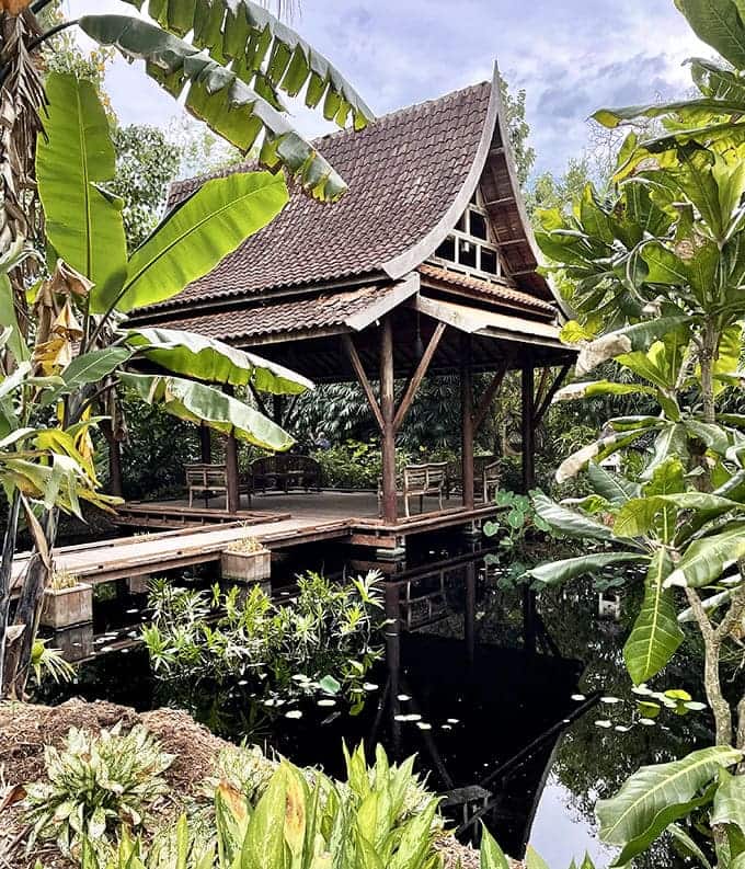 This traditional pavilion nestled among banana plants offers shaded respite and architectural interest, blending cultural elements with natural beauty seamlessly.