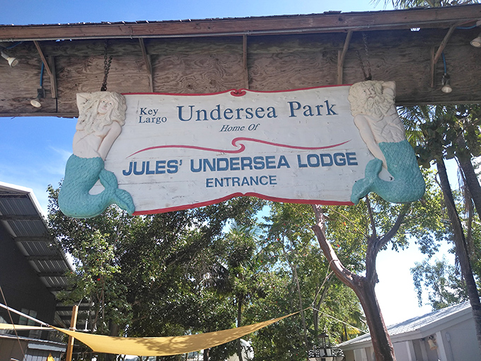 The whimsical mermaid-adorned entrance sign welcomes adventurers to Key Largo's Undersea Park, home of Jules' Undersea Lodge.