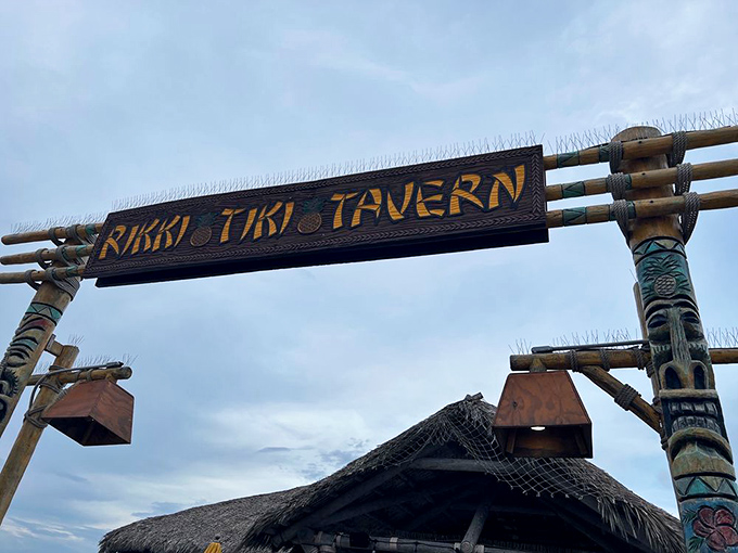 The iconic Rikki Tiki Tavern sign welcomes visitors, supported by authentic tiki totems – your first hint that this isn't just another beach bar.