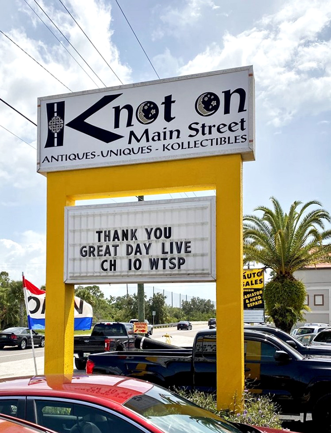 The iconic Knot On Main Street sign stands tall against Florida's blue sky, its distinctive yellow frame guiding antique lovers to this treasure-filled destination.