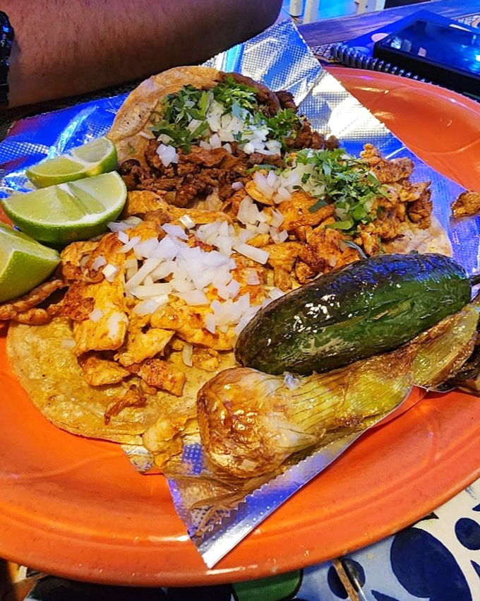 Street tacos served traditional-style with cilantro, onion, and lime&mdash;simple ingredients that create complex happiness in every bite.