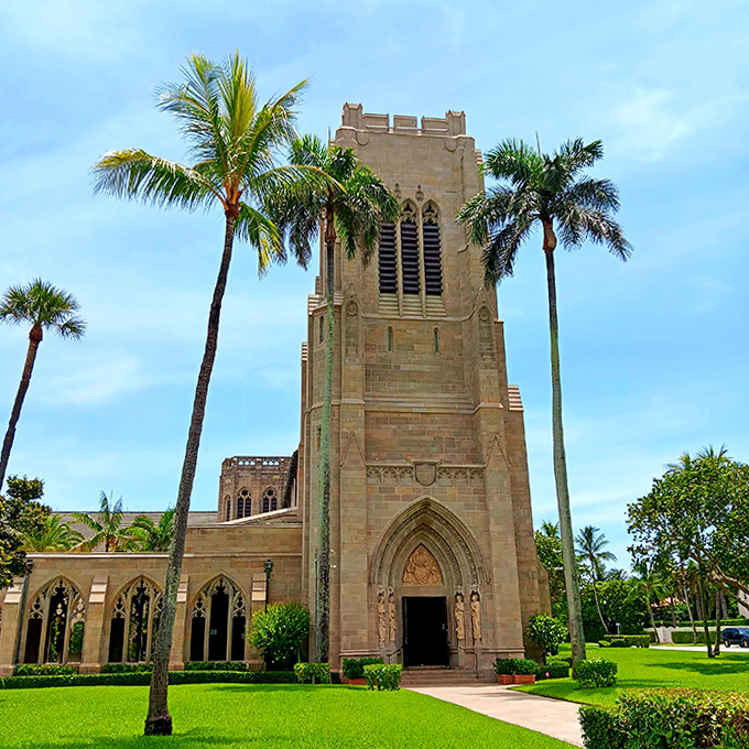 The church tower reaches skyward between royal palms, a limestone exclamation point declaring Gothic grandeur in the heart of sunny Florida.