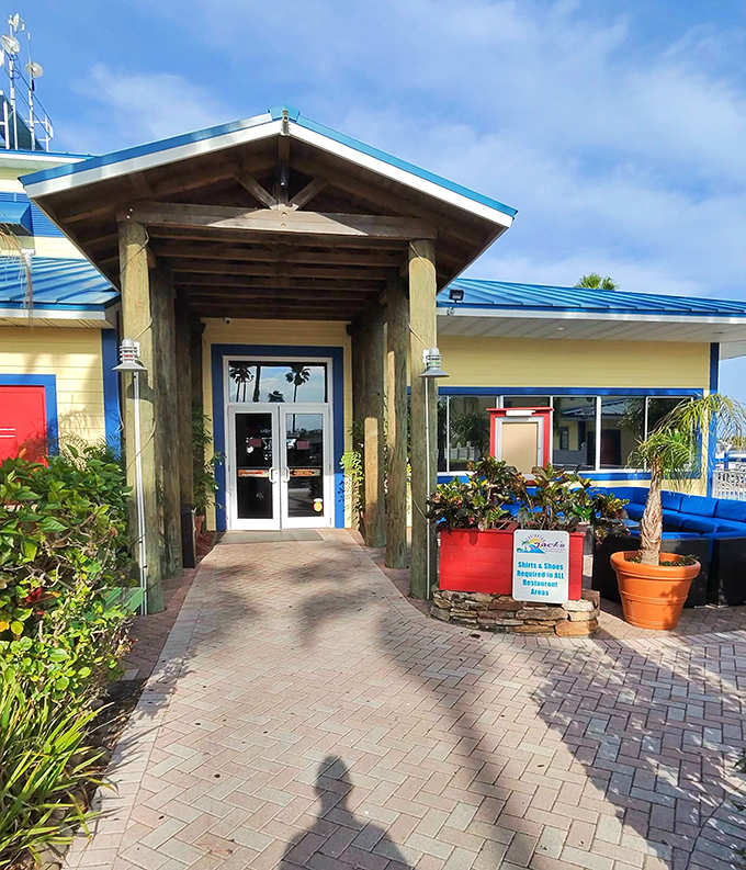 The entrance pathway, lined with tropical plants, serves as a perfect transition from everyday life to waterfront vacation mode.