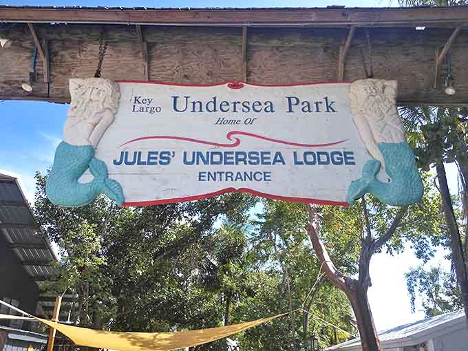 The whimsical entrance sign, complete with mermaid guardians, sets the tone for the underwater adventure that awaits below.