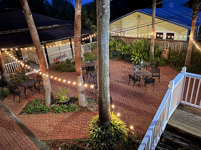 As evening falls, string lights illuminate the courtyard dining area &ndash; the perfect setting to savor Florida's most magical hidden gem.