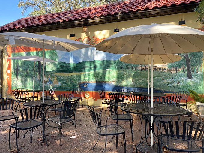 The outdoor patio area invites lingering, with umbrellas providing shade and a painted mural creating ambiance that makes every meal feel like a mini vacation.