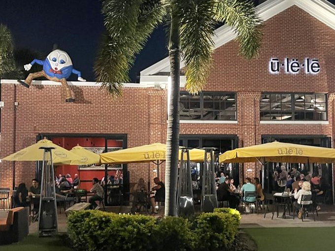 As night falls, Humpty Dumpty keeps watch from his perch atop Ulele's roof, a whimsical guardian overlooking the Tampa dining scene.