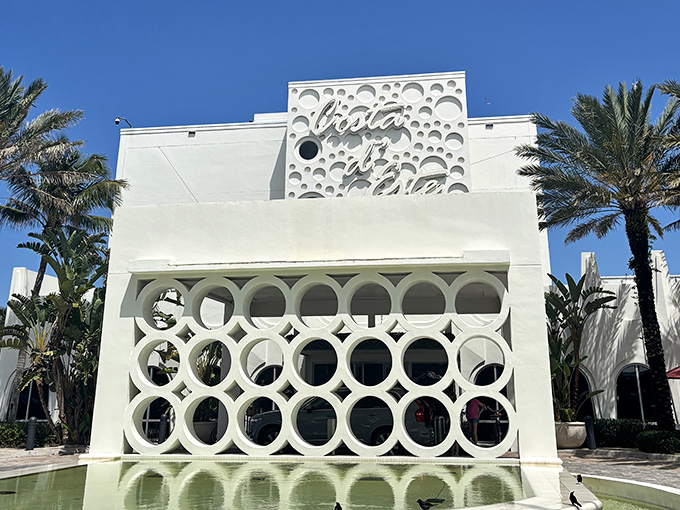 "Costa d'Este" announces itself proudly on the building's fa&ccedil;ade, the distinctive circular cutouts creating a pattern that's both modern and timeless.