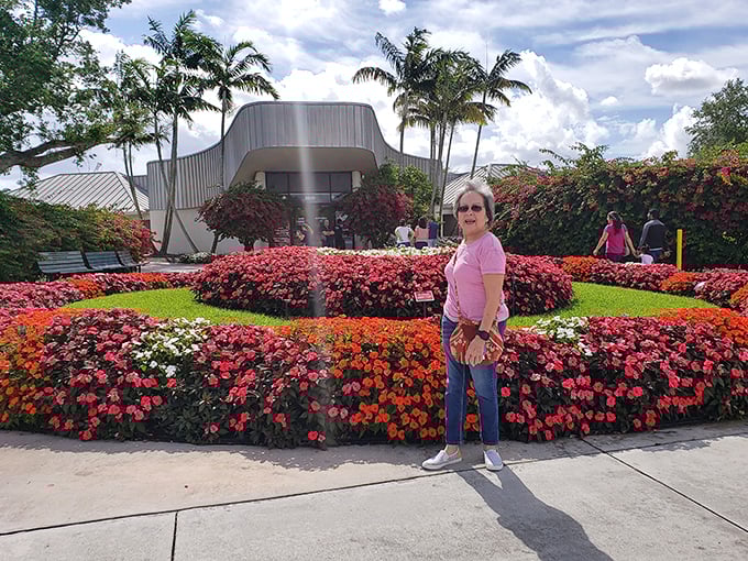 Visitors enjoy the vibrant flower displays surrounding the entrance, a colorful preview of the wonders waiting inside.