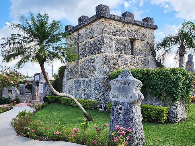 The entrance to Coral Castle features an impressive stone sign and castle-like walls, inviting visitors into a world of stone wonders.
