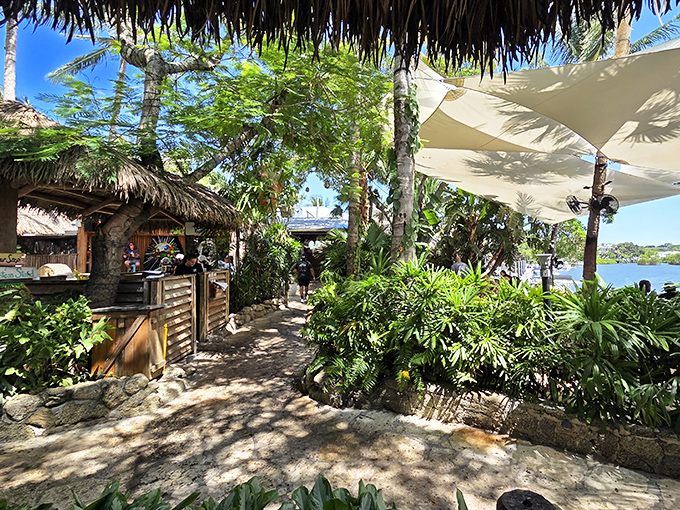 Winding paths through lush greenery lead to waterfront dining at Guanabanas, where every table feels like a private tropical escape.