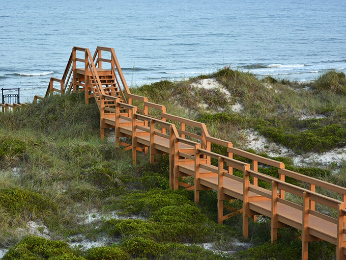 Wooden boardwalks meander through sea oats and dunes, protecting the fragile ecosystem while guiding visitors to pristine beaches beyond.