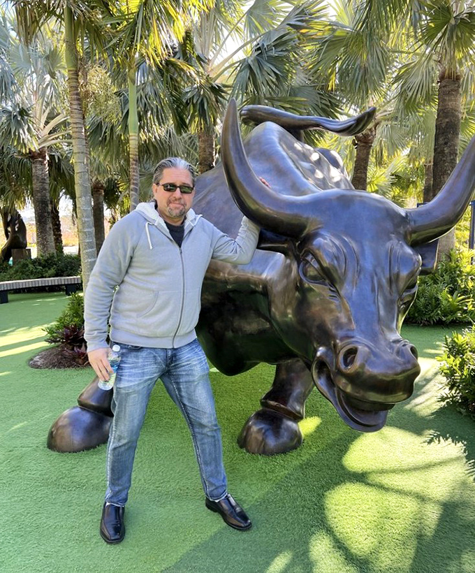 This imposing bronze bull stands guard in the garden, its powerful presence drawing admirers who can't resist posing alongside.