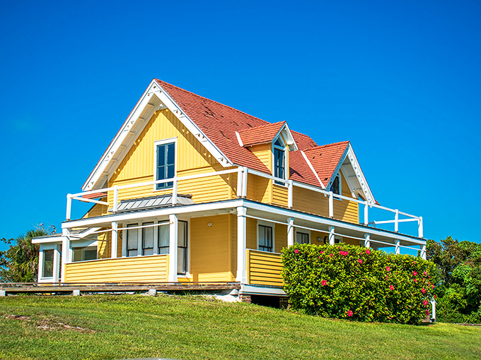 The cheerful yellow Caretaker's House stands as a sunny sentinel of history, its weathered porch whispering tales of bygone eras.