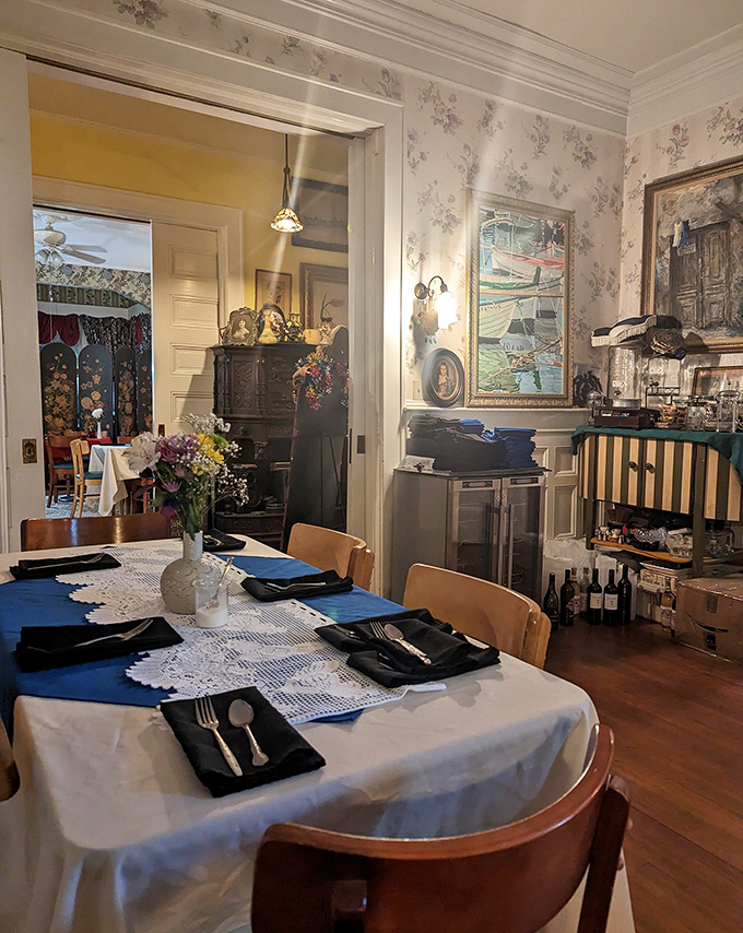 Elegant place settings await guests in the dining room, where fine linens and antique silverware set the stage for meals shared with both the living and perhaps... others.