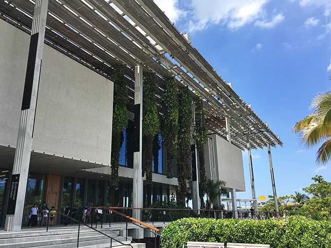Vertical gardens cascade from the museum's canopy, nature's curtains swaying in the ocean breeze like green performers taking their bow.