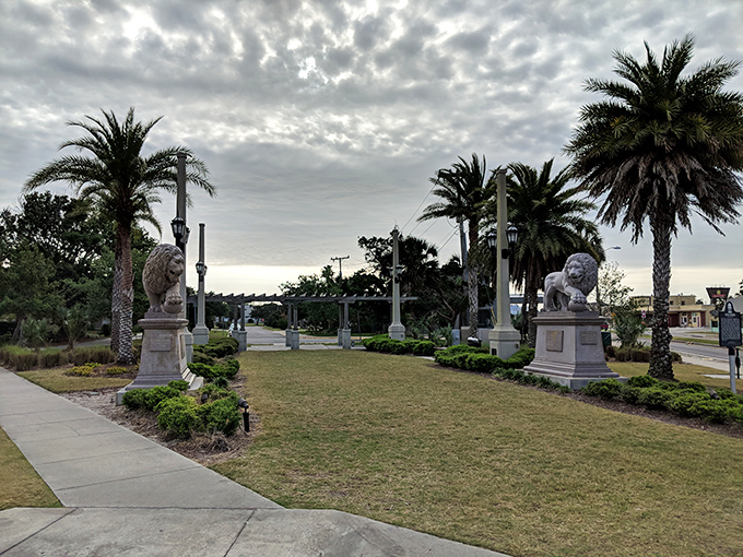 Majestic palm trees and stone lions stand guard at the bridge entrance, welcoming visitors like ancient sentinels with Florida flair.