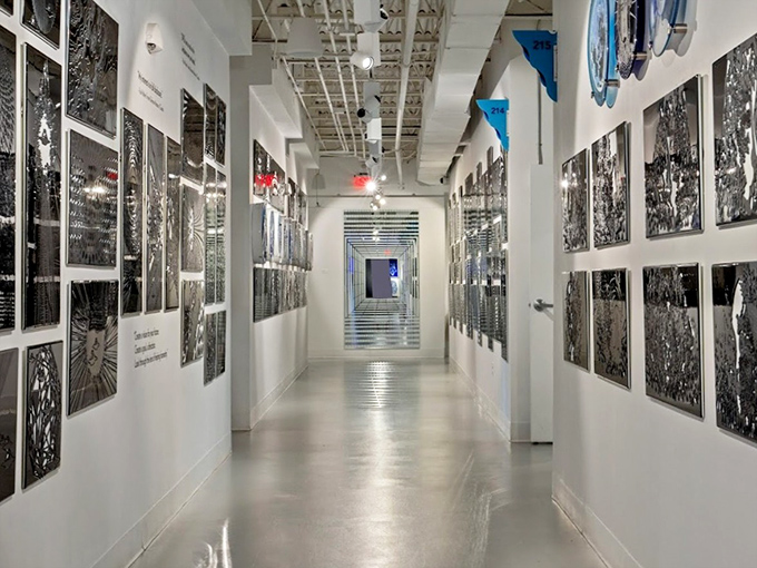 A corridor lined with monochromatic glass art creates an almost hypnotic tunnel effect, drawing visitors deeper into the museum's wonders.