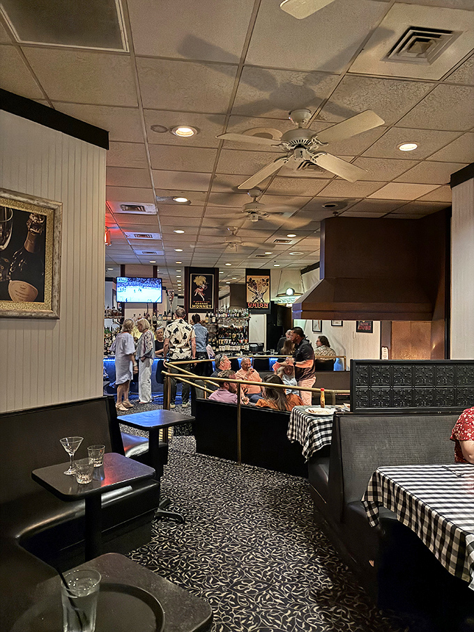 Black and white checkered tablecloths set the stage for culinary drama, while ceiling fans lazily spin stories of decades of delicious memories.