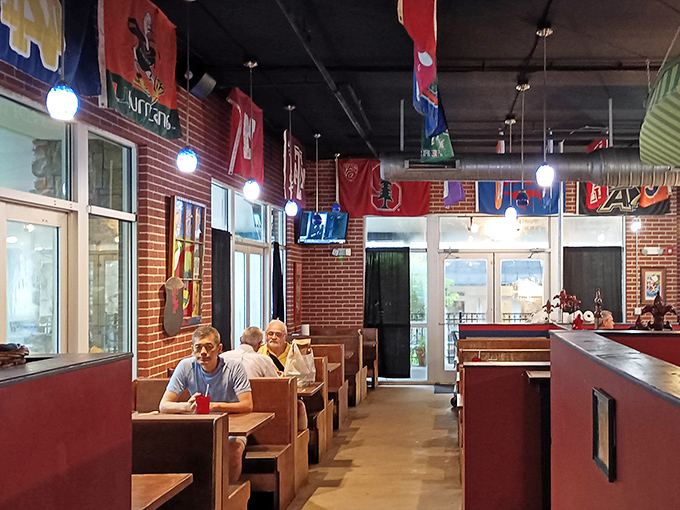 College pennants create a colorful canopy above wooden booths where diners focus on the serious business of enjoying authentic Cajun cuisine.