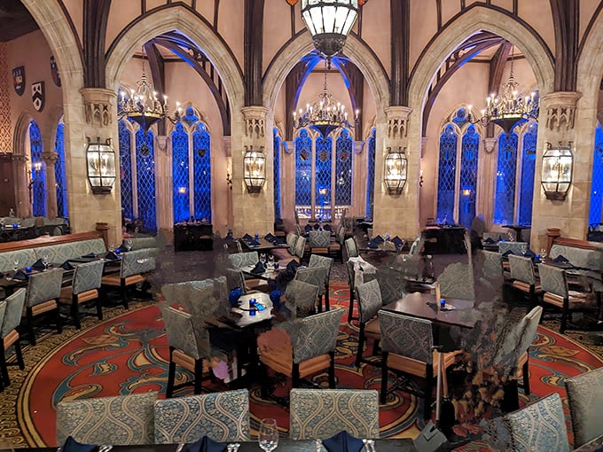 Medieval magnificence meets Disney magic in this breathtaking dining hall, where blue-tinted windows cast an otherworldly glow across each table.