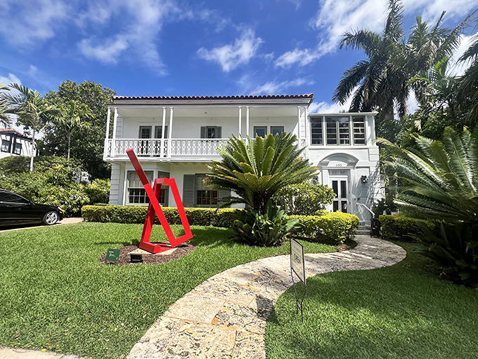 A pristine white residence with a bold red sculpture gracing the front lawn &ndash; Florida modernism at its most inviting.