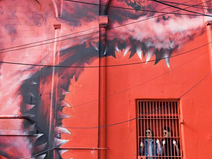 Nature meets fantasy in this vibrant mural where even the shark-toothed walls seem to smile at passersby.