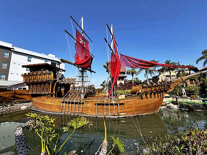 This isn't just any pirate ship &ndash; it's a fully realized wooden vessel complete with billowing crimson sails that would make Captain Hook jealous.