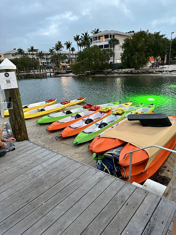 Wooden pier: The gateway to adventure stretches into calm waters, where colorful kayaks wait like patient steeds ready for twilight exploration.