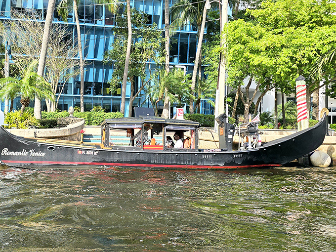 Traditional craftsmanship meets tropical scenery as the gondola navigates past modern waterfront architecture and swaying palm trees.