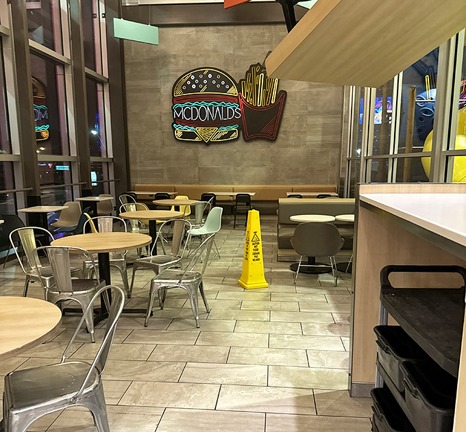 Sleek modern interior with neon burger and fries art transforms the typical McDonald's experience into something unexpectedly stylish.
