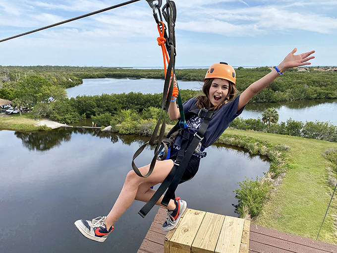 Pure joy captured mid-flight! Nothing says "I'm living my best life" like dangling 60 feet above water with a smile that could outshine the Florida sun.