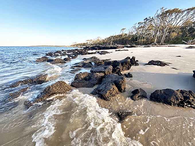 Waves crash against ancient rocks, creating a rhythmic soundtrack to the visual drama of this unique shoreline.