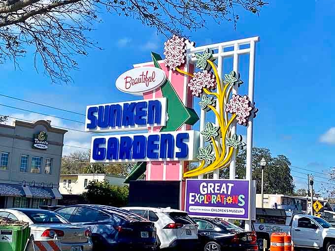 The welcoming sign at Butterfly World, framed by vibrant bougainvillea, promises winged wonders just beyond its gates.