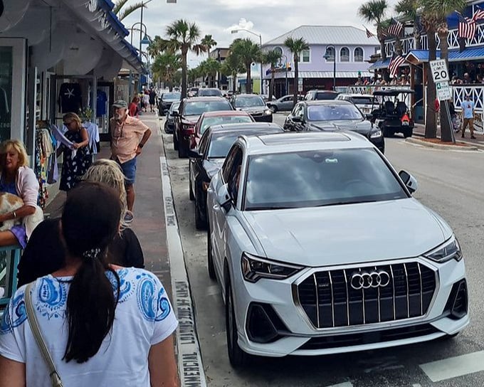 Flagler Avenue buzzes with local charm as shoppers browse boutiques and diners enjoy sidewalk cafes under Florida's endless blue sky.