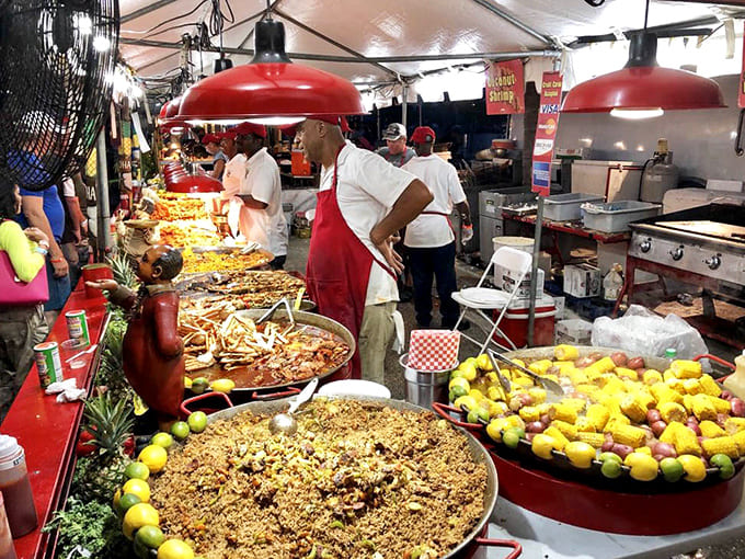 Giant skillets sizzle with seafood magic as chefs in red work their culinary wizardry for the waiting crowds.