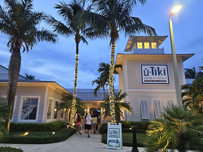 U-Tiki Beach welcomes evening visitors with palm trees wrapped in twinkling lights, creating a magical coastal atmosphere.