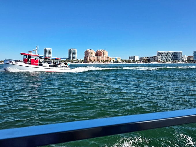 A lone boat rests on Clearwater's shore as silver-tipped waves catch the sunlight, creating a moment of serenity on this popular beach.