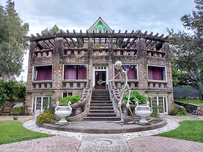 The front entrance stands sentinel with its skeletal guardians, as if Tim Burton designed a tropical getaway for his most eccentric characters.