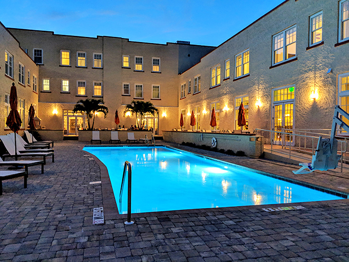 The courtyard pool glows with invitation at dusk, surrounded by comfortable loungers perfect for post-swim relaxation.