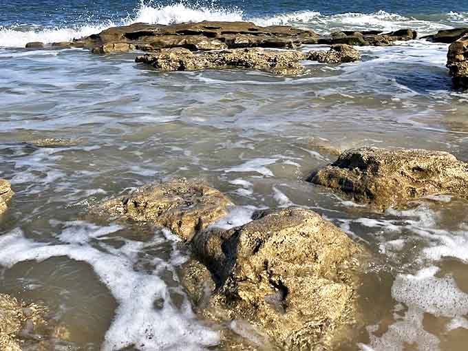 The Atlantic performs its eternal dance with the shoreline, sending frothy waves cascading over weathered coquina formations.