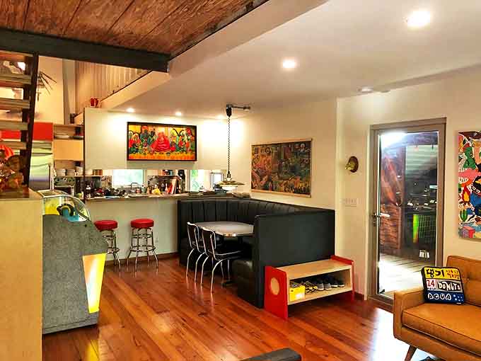 The kitchen and dining area blend retro charm with modern convenience &ndash; that curved booth isn't just seating, it's a time machine with table service.