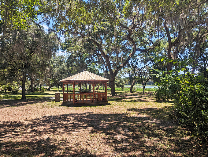 A peaceful gazebo stands sentinel by the water, offering shade and serenity for visitors seeking a moment of reflection.