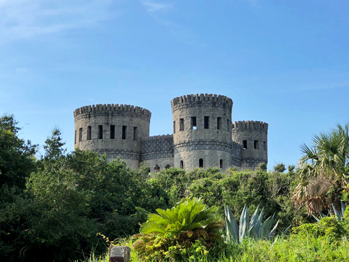 Castle Otttis rises dramatically from the Florida landscape, its trio of stone towers creating an unexpected medieval silhouette against the bright blue sky.