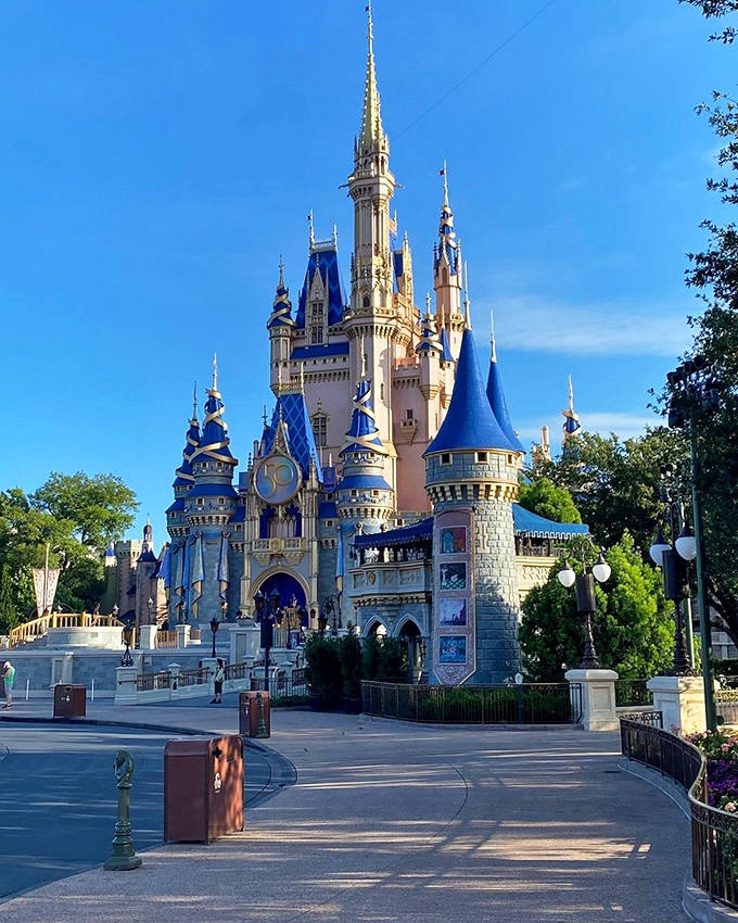 Cinderella Castle rises majestically against a perfect blue sky, its fairy-tale spires and turrets creating Disney's most iconic silhouette.