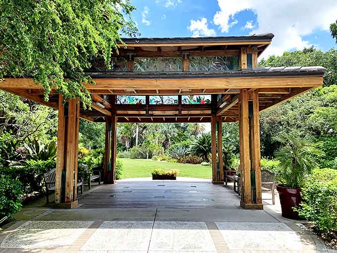 Colorful flower-lined walkway under turquoise arches at Marie Selby Botanical Gardens creates a picture-perfect garden path.